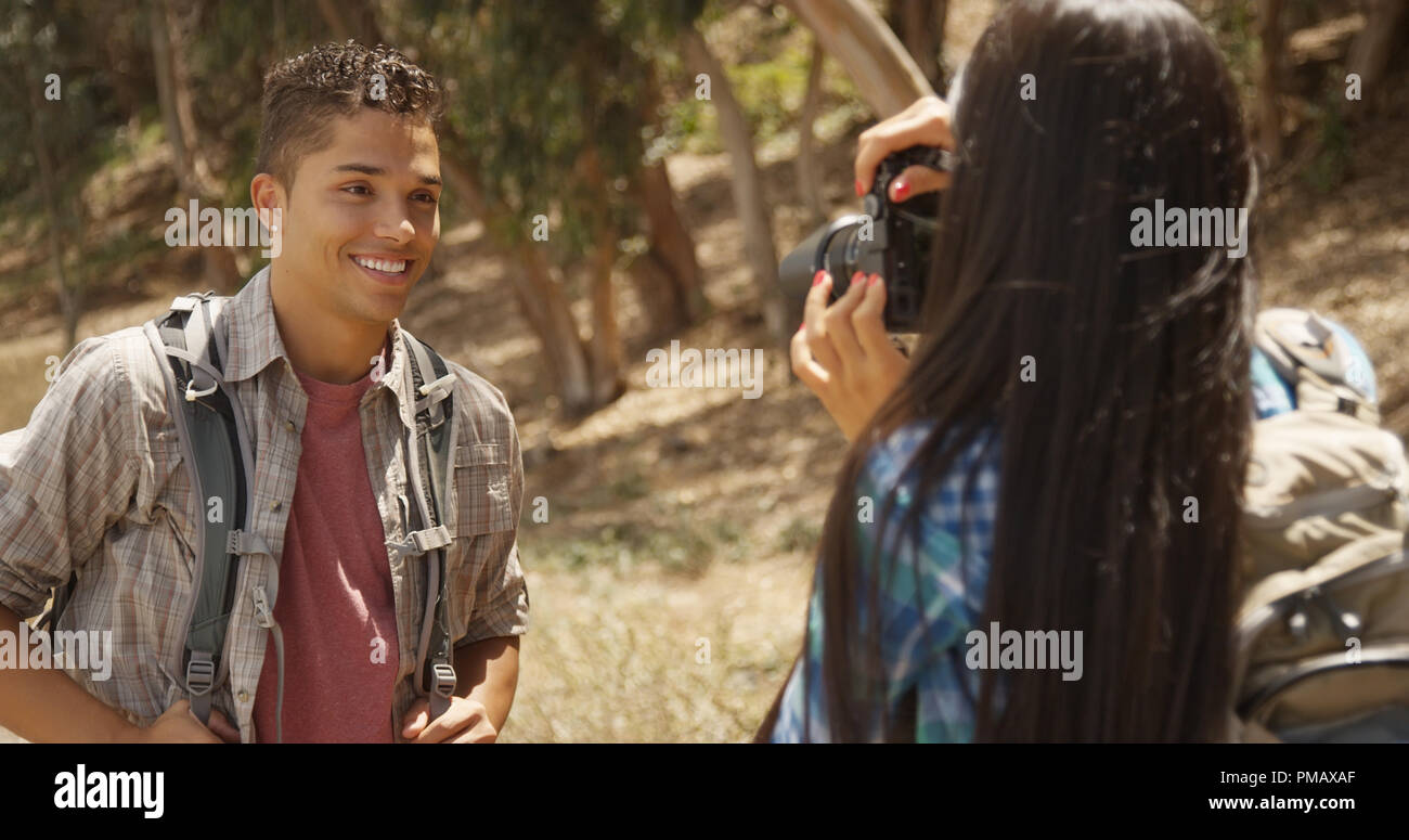 Happy young backpacker girlfriend taking pictures of boyfriend on ...