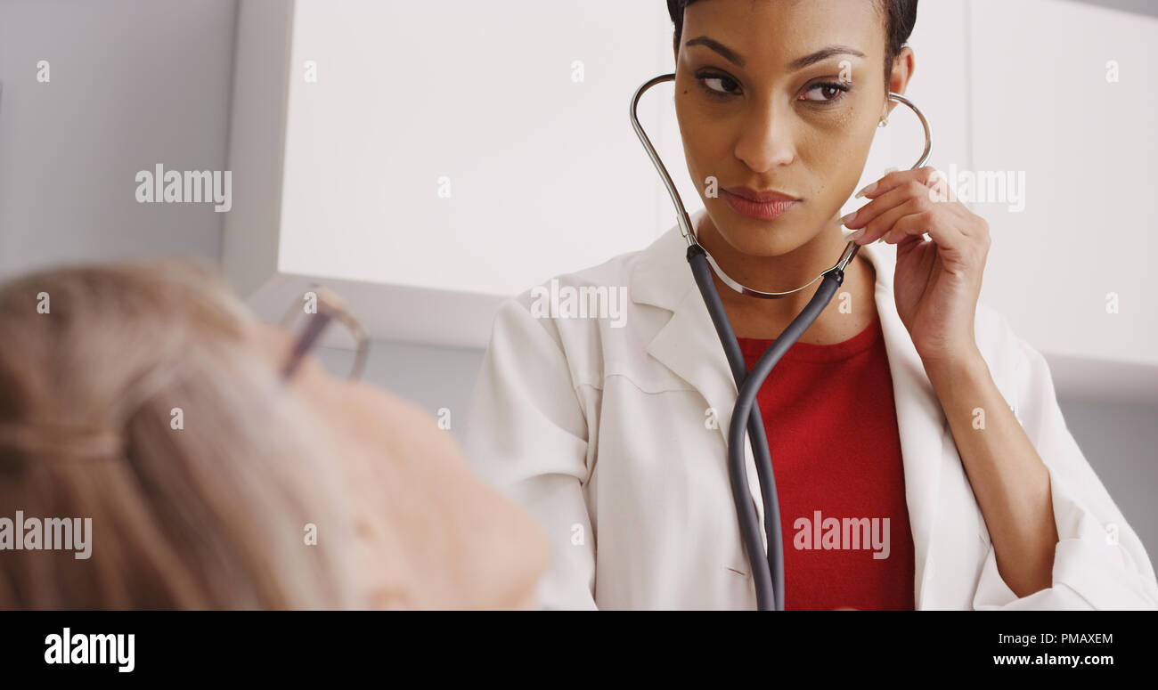 Beautiful female doctor checking patient's vitals with stethoscope ...