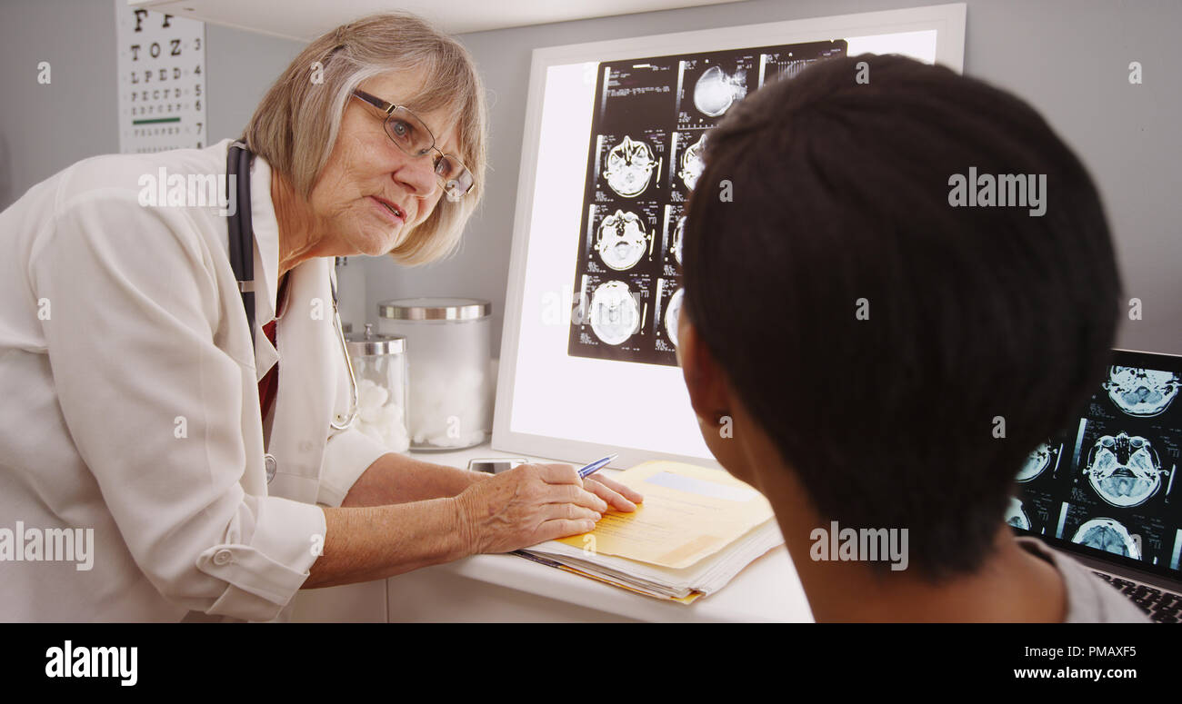 Senior female doctor reviewing x-ray results with patient Stock Photo ...