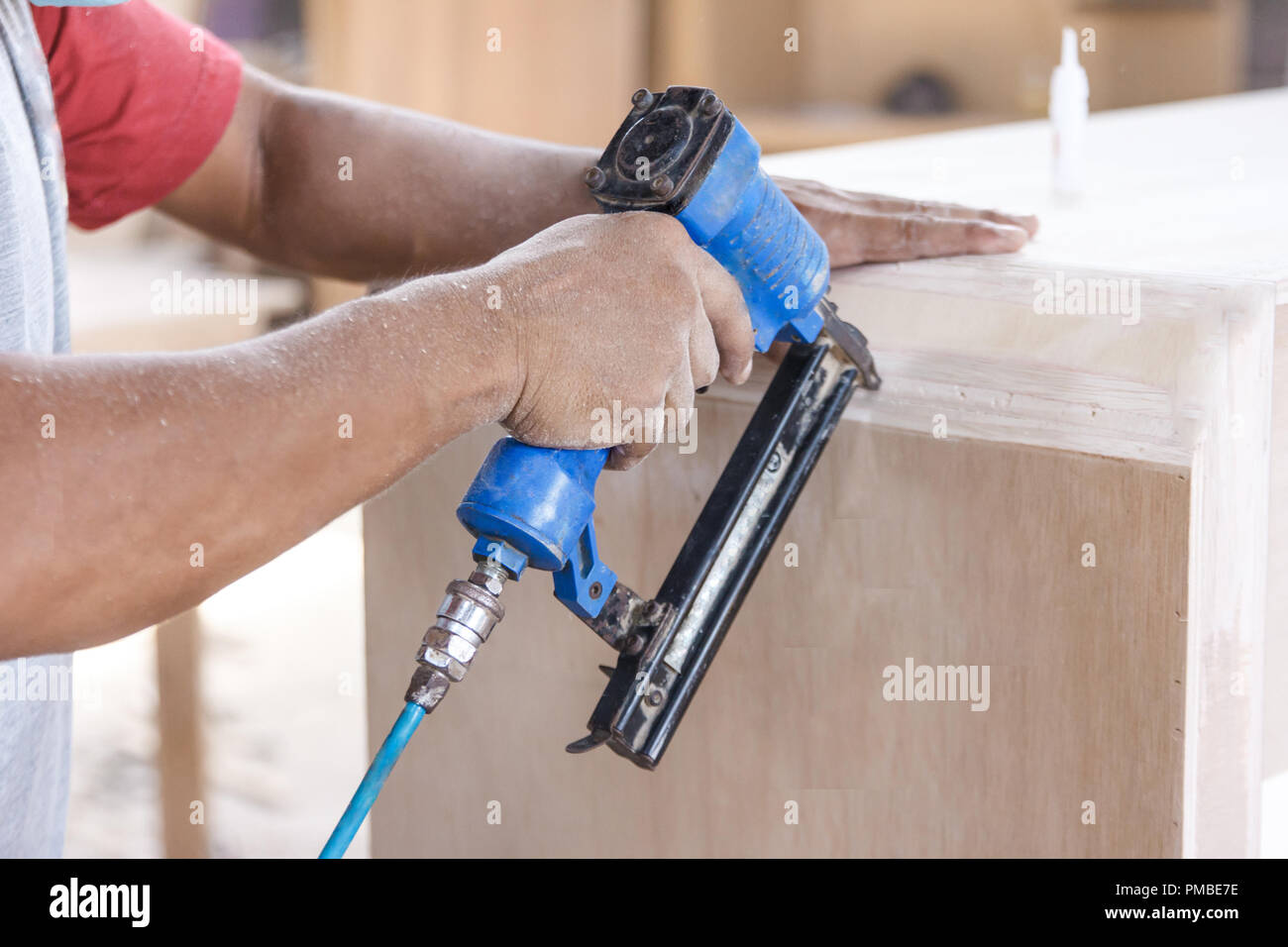 worker at carpenter workspace installing nail using pneumatic na Stock ...