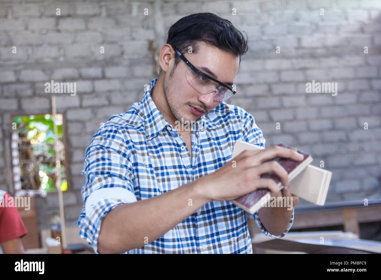 worker at carpenter workspace refining the surface of wood board Stock ...