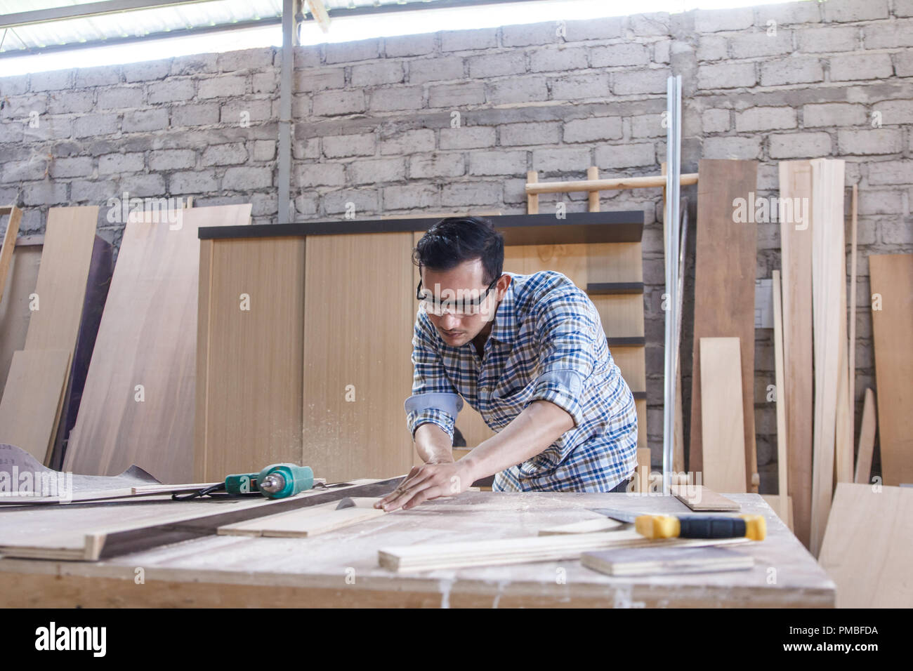 worker at carpenter workspace cutting the wood board using saw t Stock ...