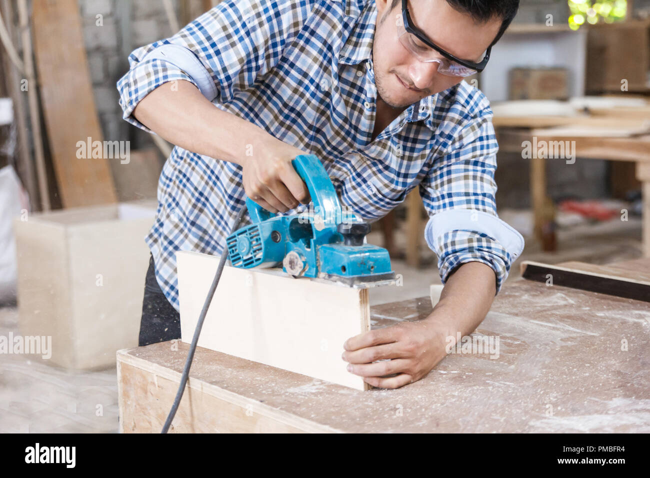 worker at carpenter workspace cutting the surface of furniture u Stock ...
