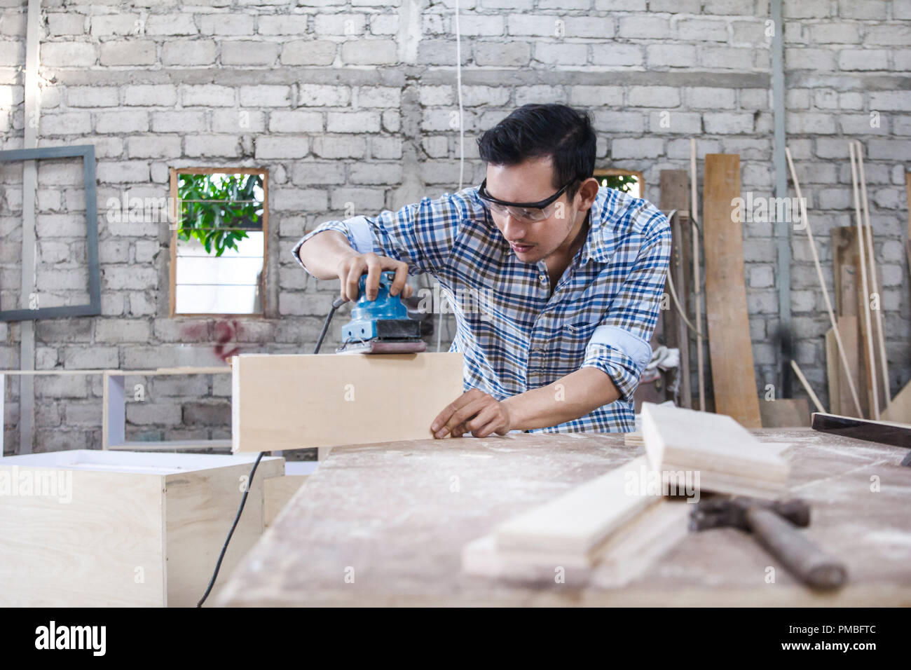 worker at carpenter workspace refining the surface of wood board Stock ...