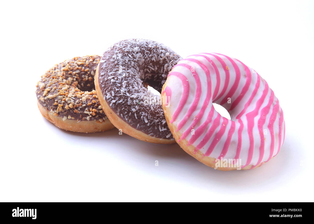 Assorted doughnuts in the glaze, colorful sprinkles and nuts on a white ...