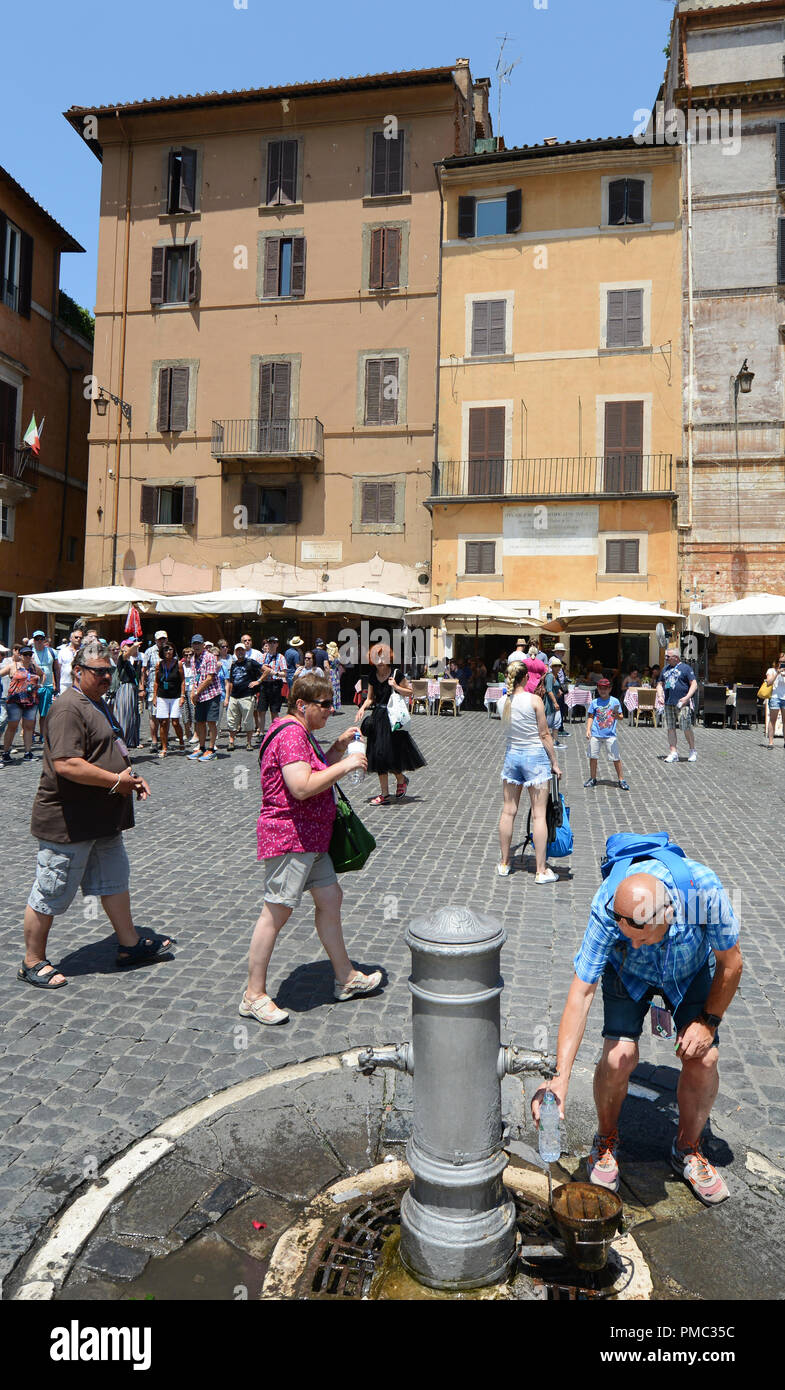 A tourist filling his water bottle from the water fountain at the ...