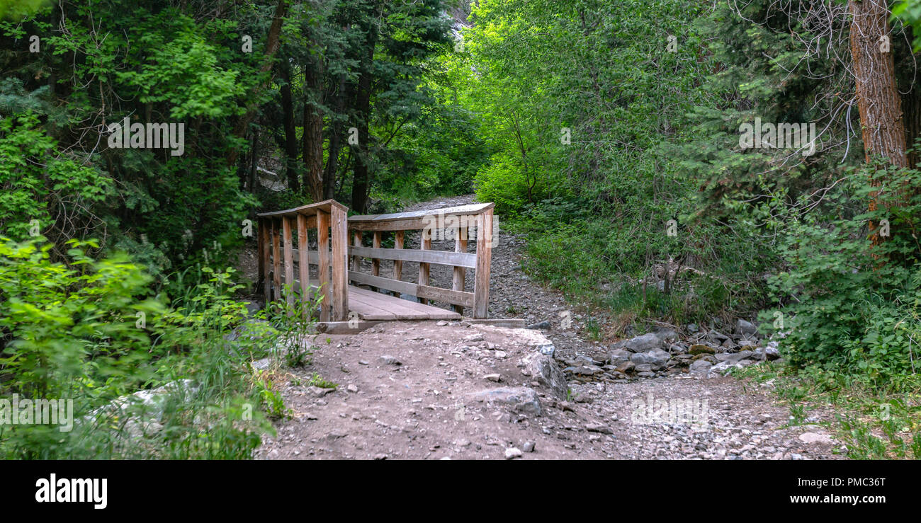 Short narrow wooden bridge over rocky stream Stock Photo - Alamy