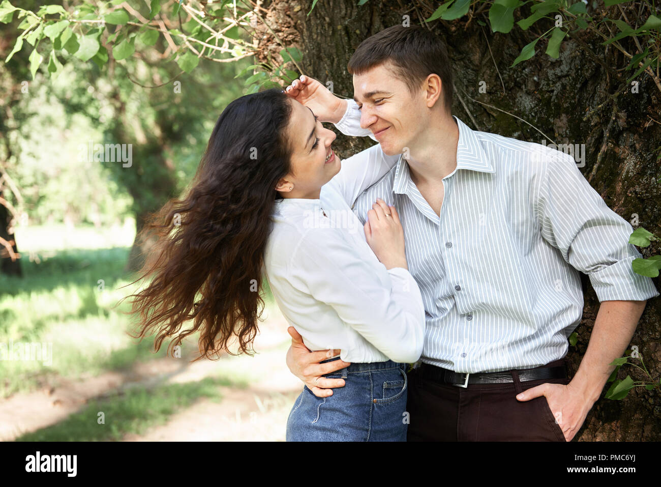 young couple walking in the forest, posing near tree, summer nature ...