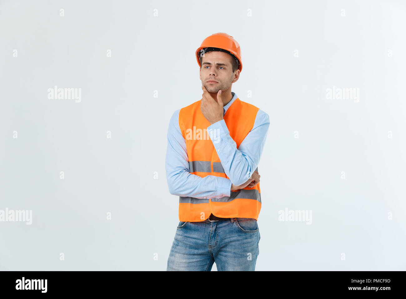 Thoughtful architect or engineer serious thinking against grey ...