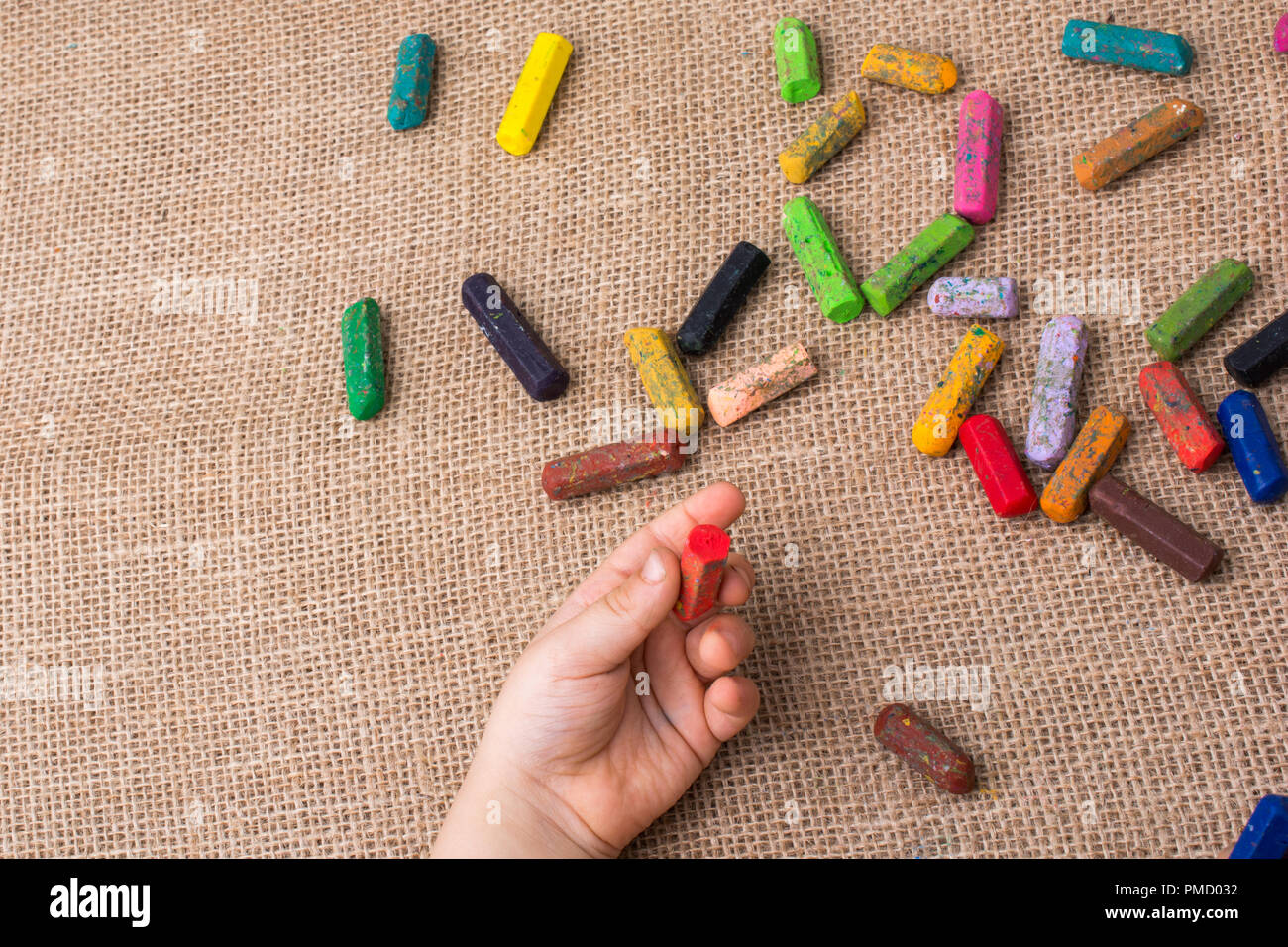 Used color crayons and a toddlers hand holding one Stock Photo - Alamy