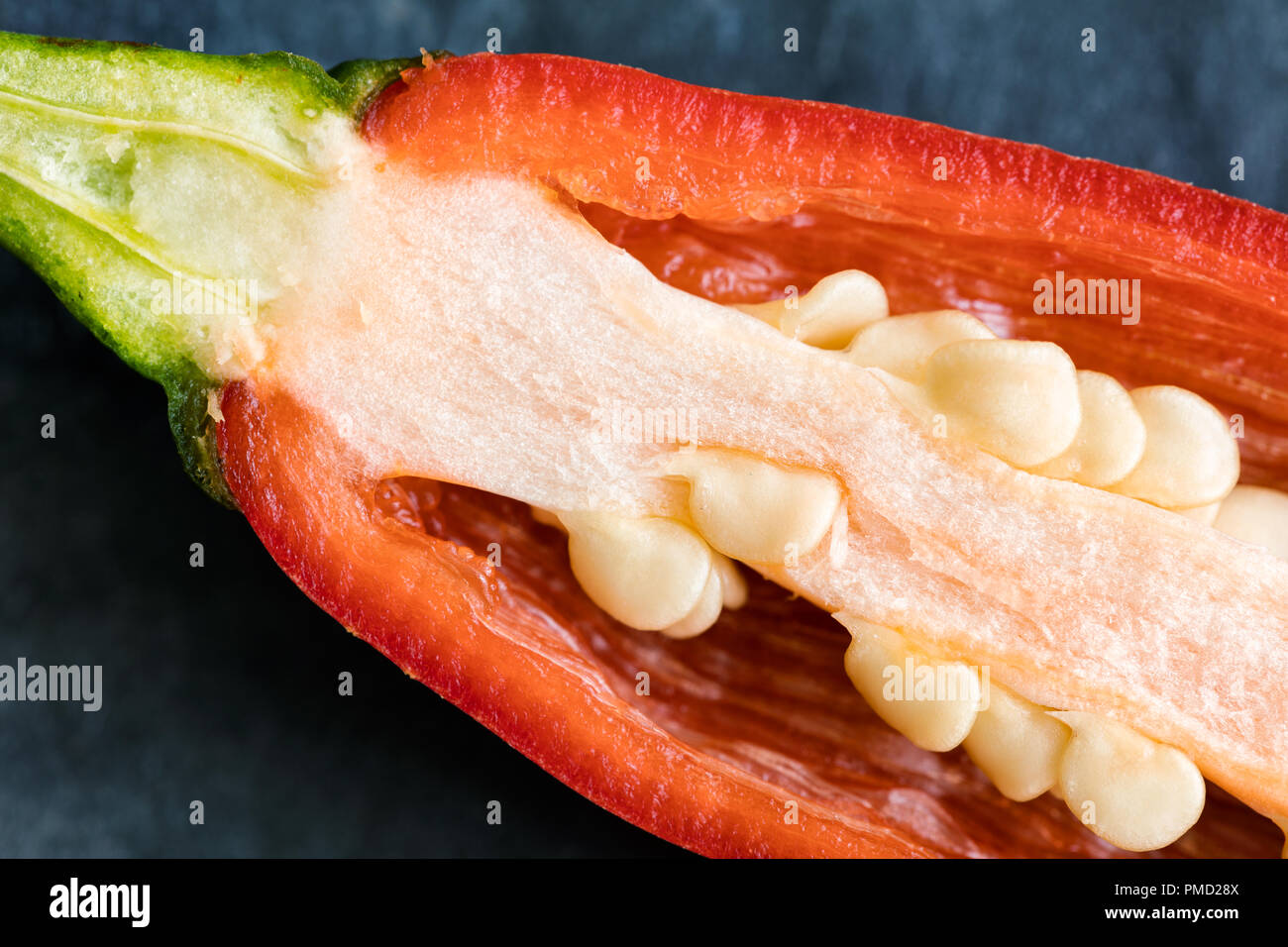 Cross cut of red chili pepper on dark background, close up Stock Photo ...