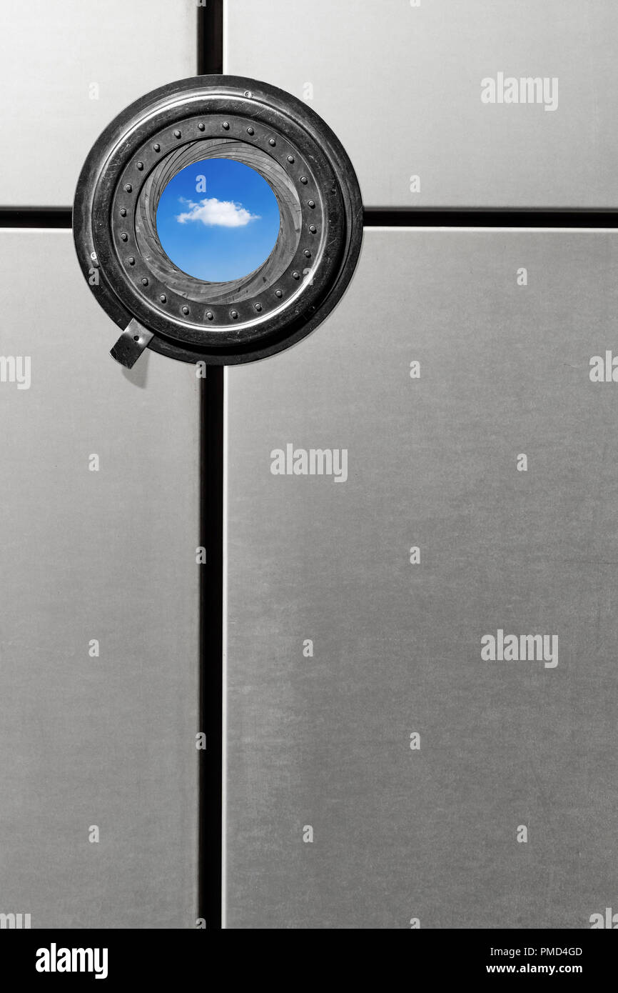 An round aperture in an metal paneling shows blue sky, vertical Stock ...