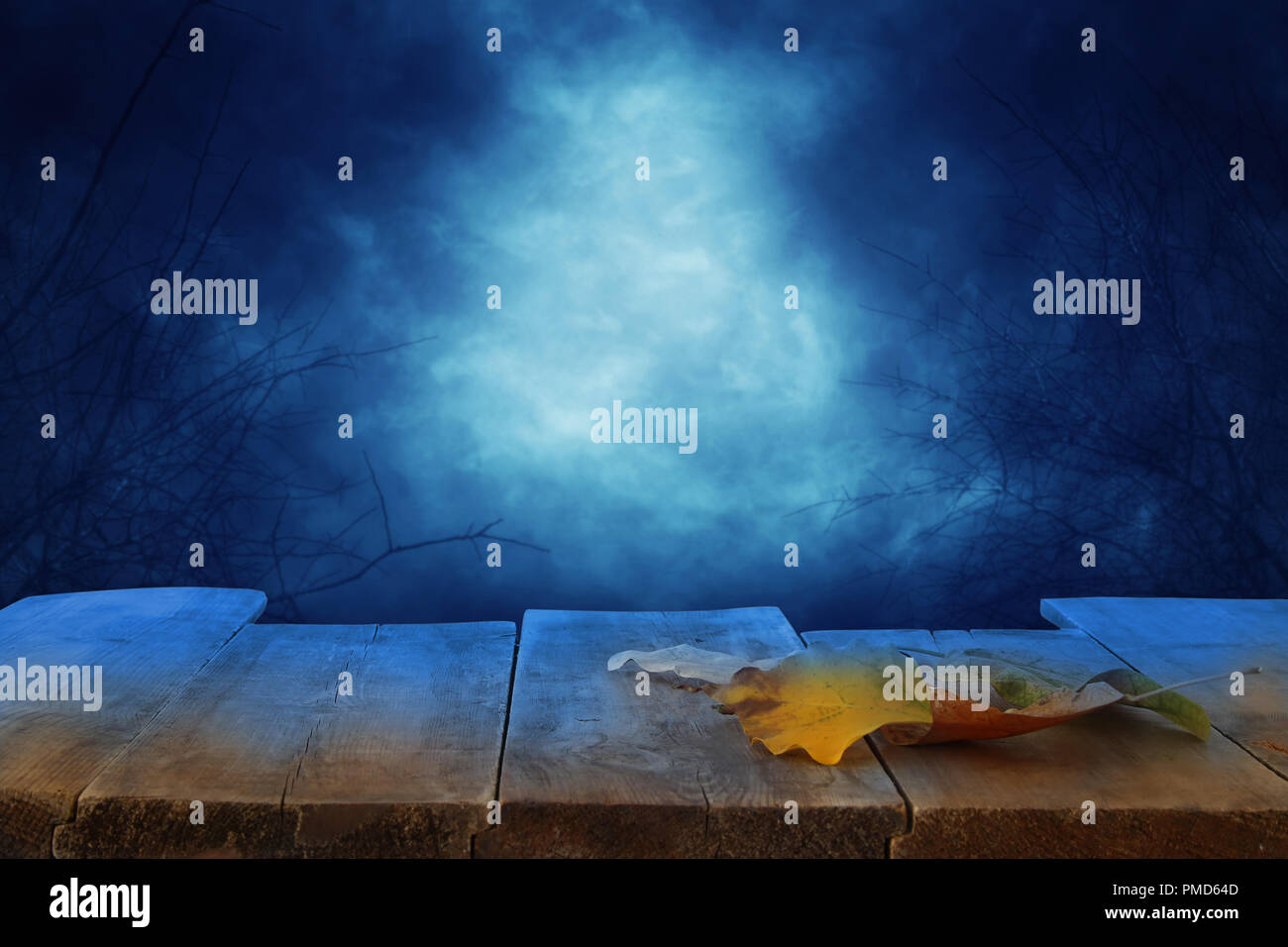 Halloween holiday concept. Empty rustic table in front of scary and ...