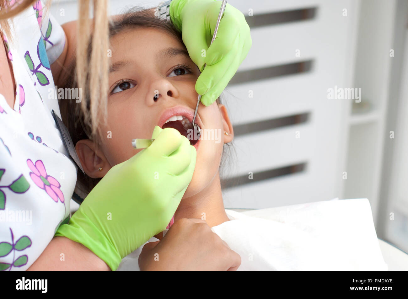 Child visits the dentist, sitting in his chair and opened her mouth for ...