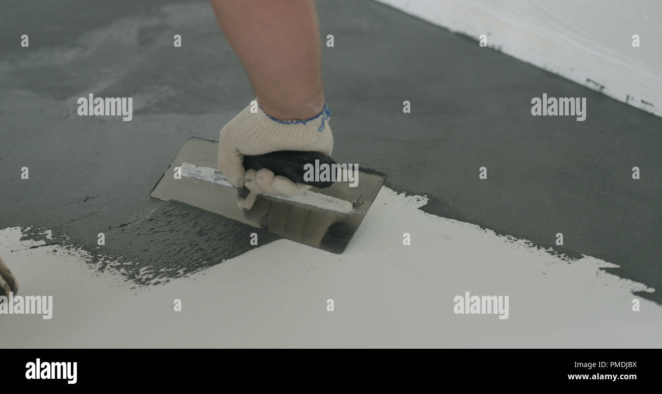 closeup male worker applying micro concrete plaster coating on the ...