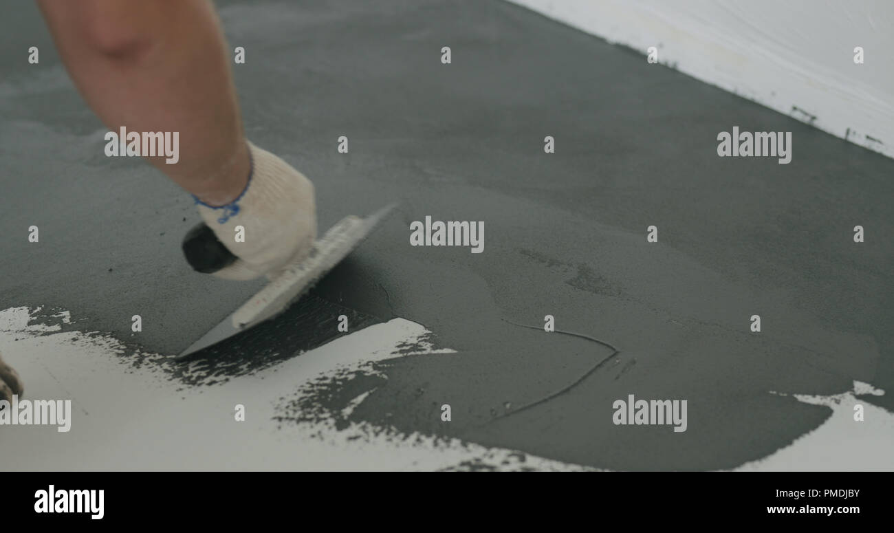 closeup male worker applying micro concrete plaster coating on the ...