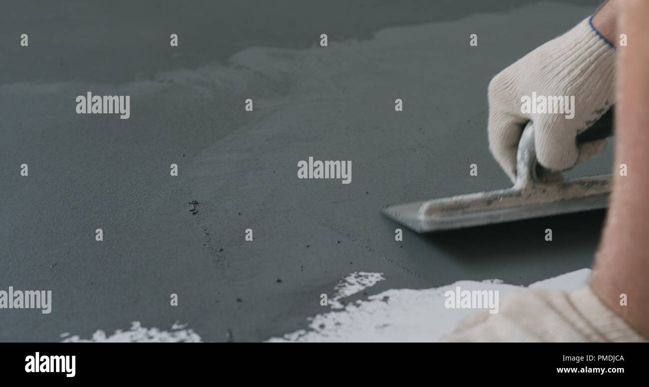 closeup male worker applying micro concrete plaster coating on the ...
