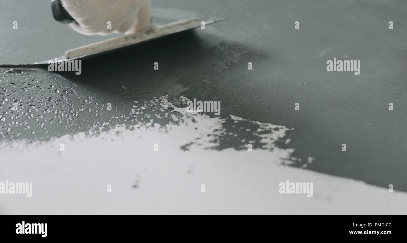 closeup male worker applying micro concrete plaster coating on the ...