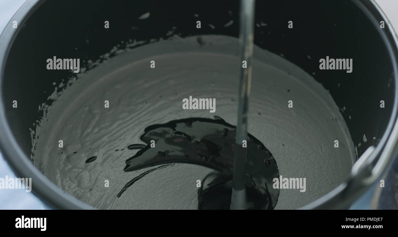 adding black ink to micro concrete plaster Stock Photo - Alamy