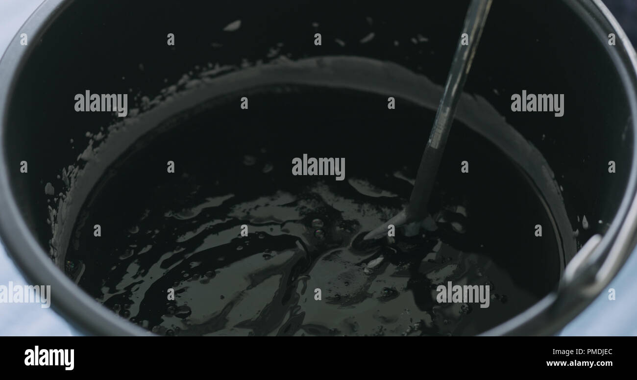 adding black ink to micro concrete plaster Stock Photo - Alamy