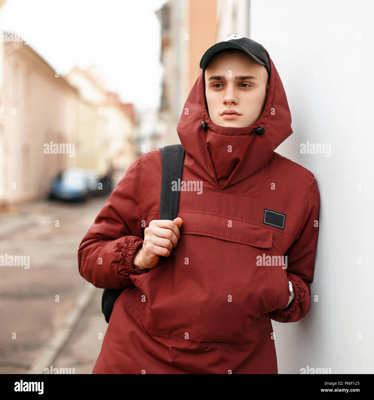 Stylish handsome man in a fashionable red sports jacket with a cap and ...