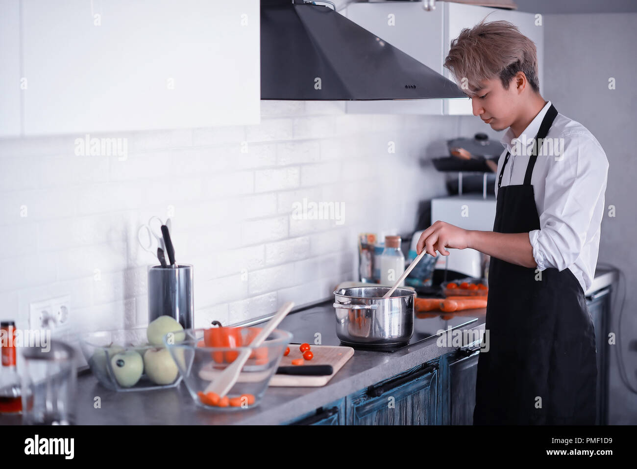 Asian cook in the kitchen prepares food in a cook suit Stock Photo - Alamy