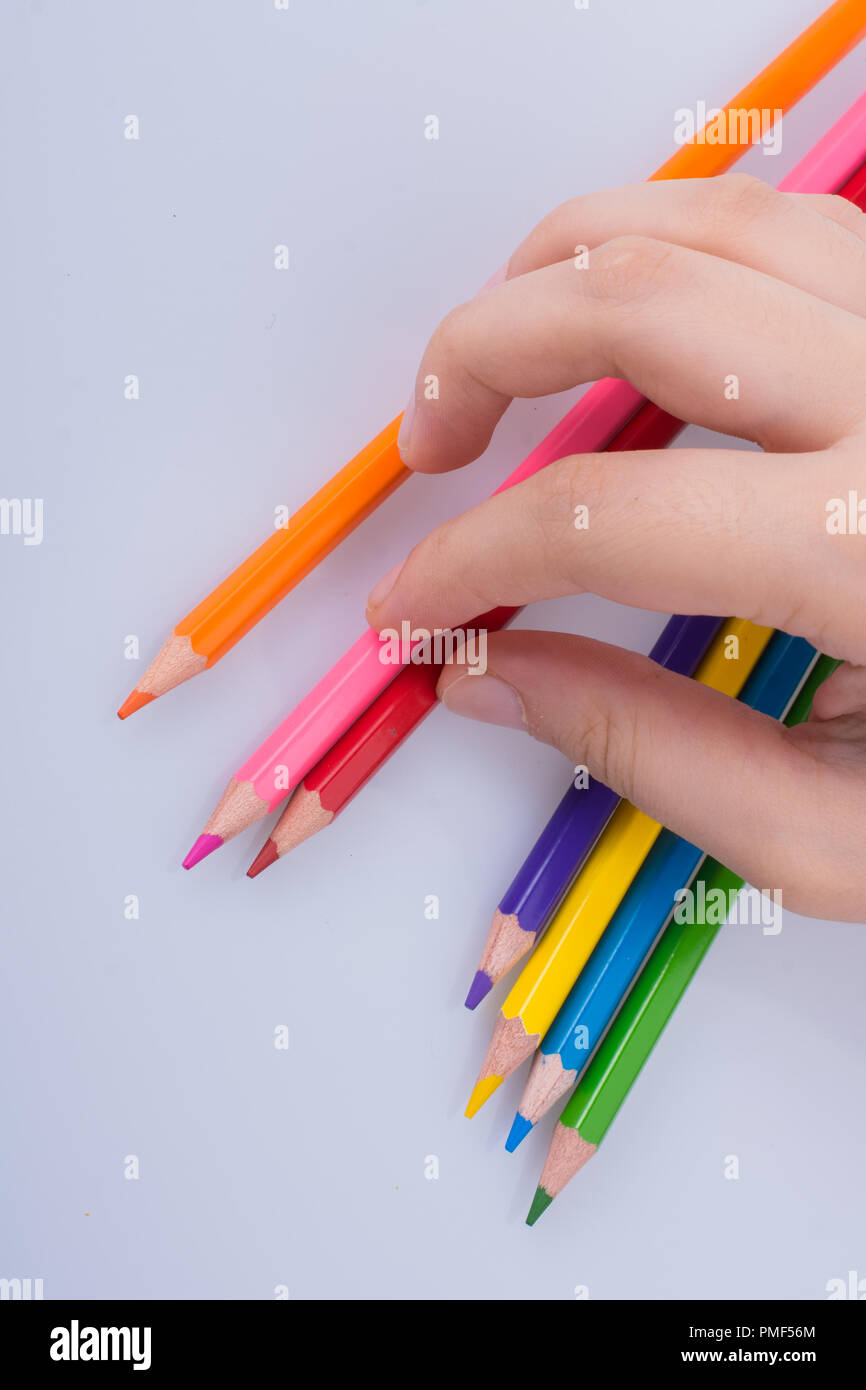 Hand holding color Pencils placed on a white background Stock Photo - Alamy