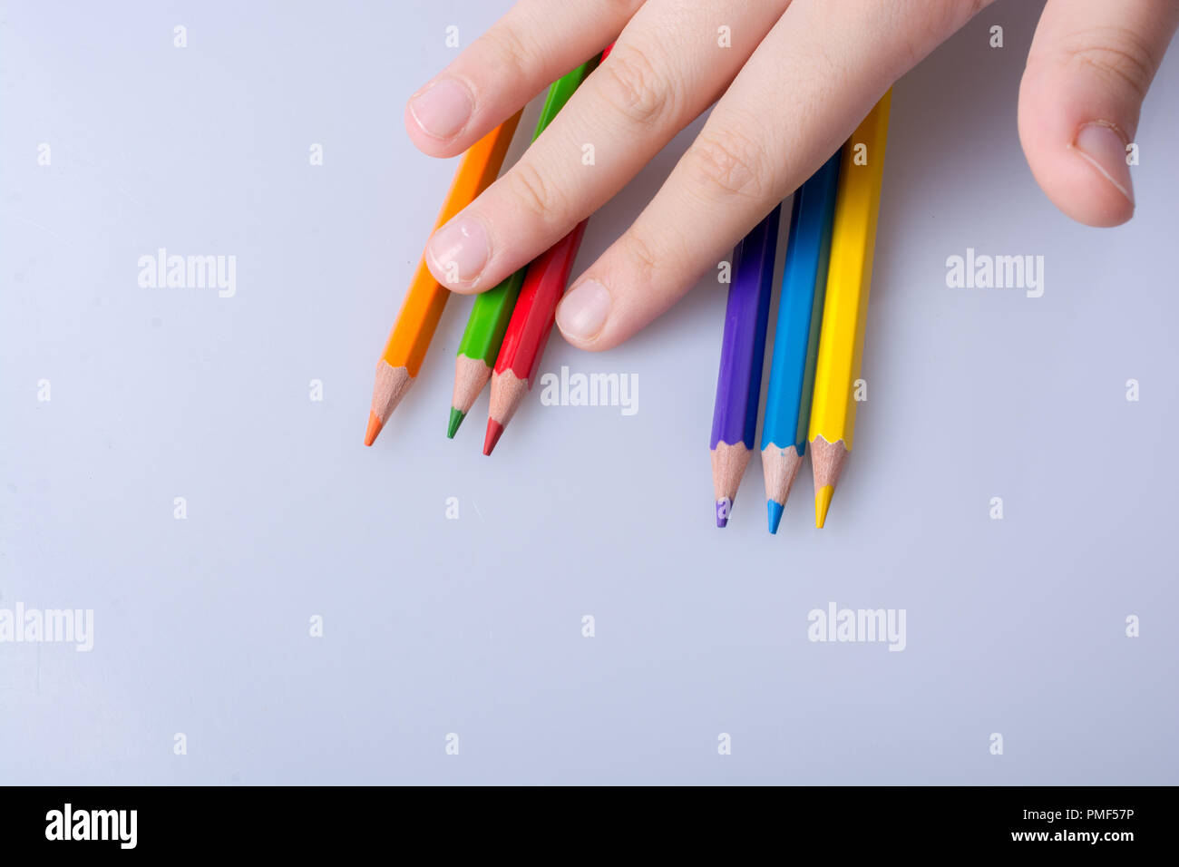 Hand holding color Pencils placed on a white background Stock Photo - Alamy