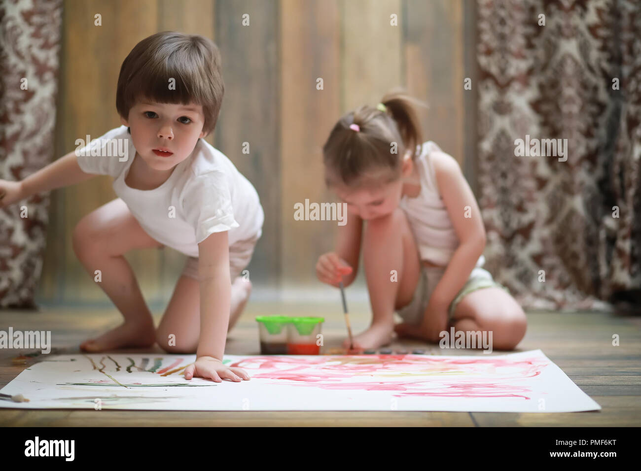 Little children paint on a large sheet of paper Stock Photo - Alamy