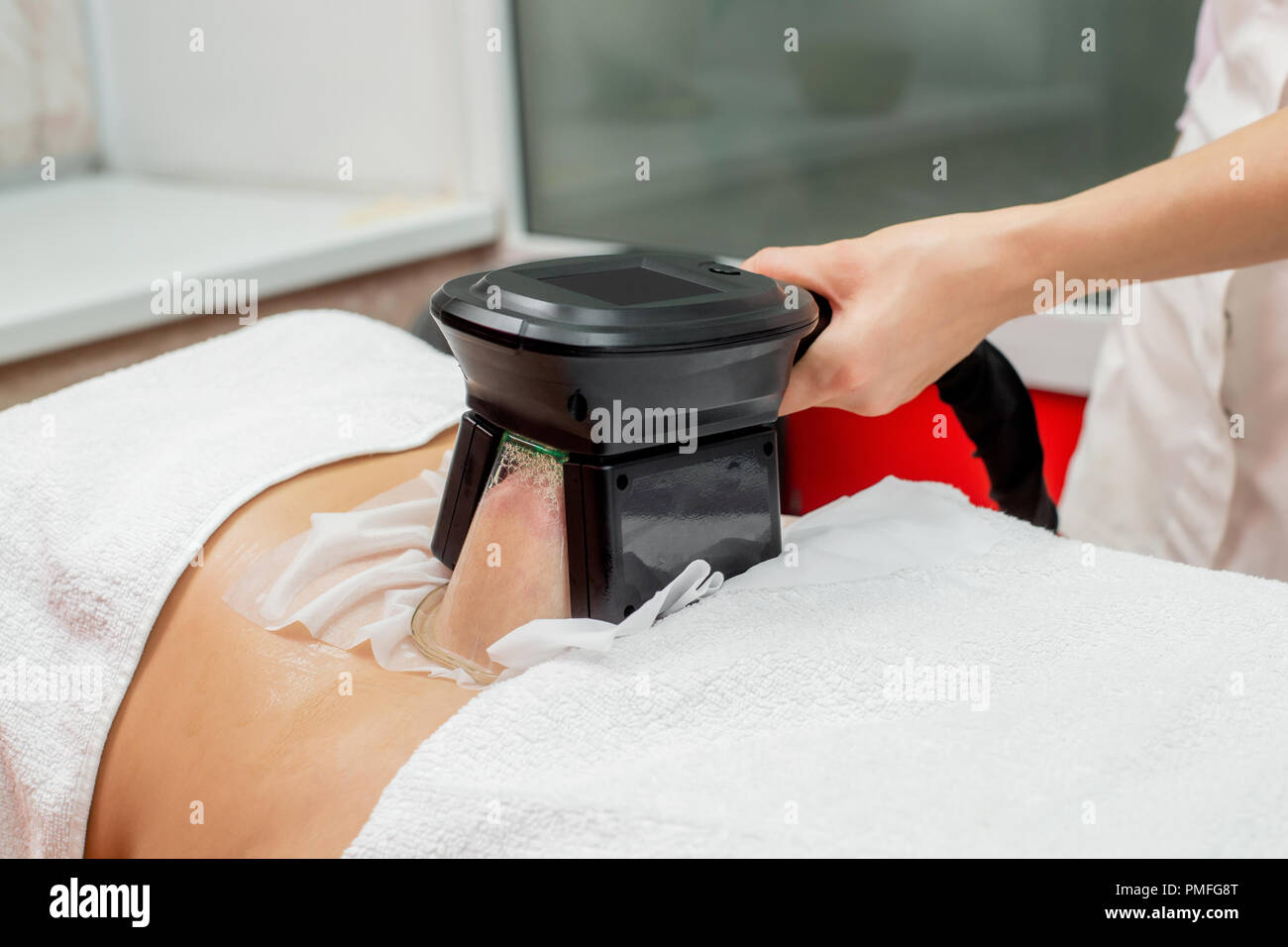 Woman getting cryolipolysis fat treatment procedure in professional ...