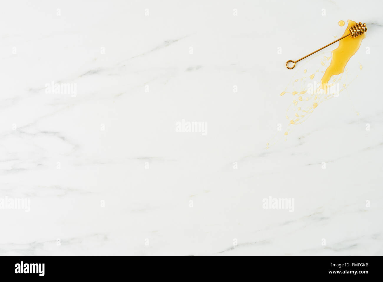 Honey concept. Top view of golden dipper with honey on white marble ...