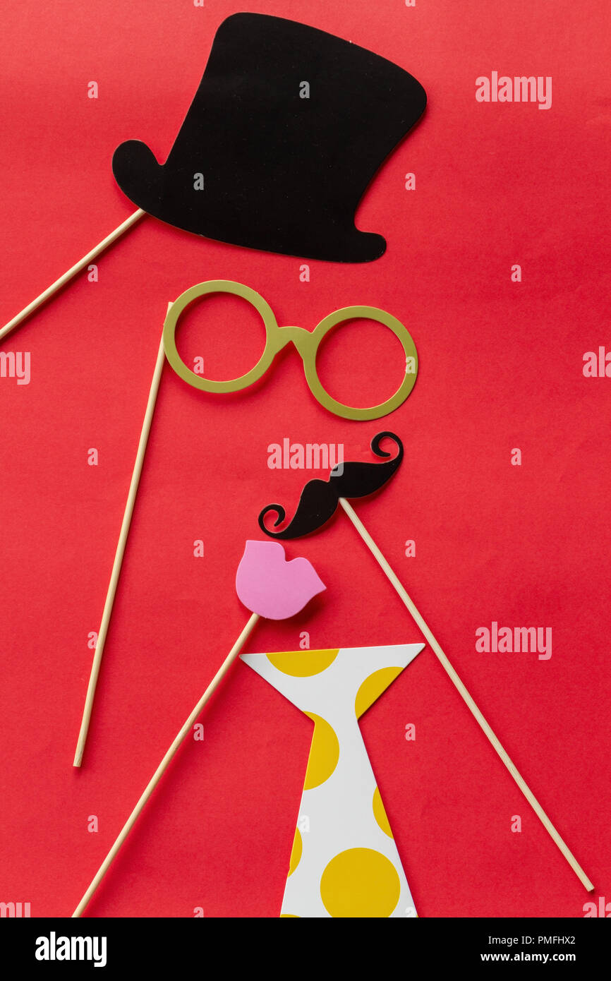 Paper props for holidays and parties on red background Stock Photo - Alamy