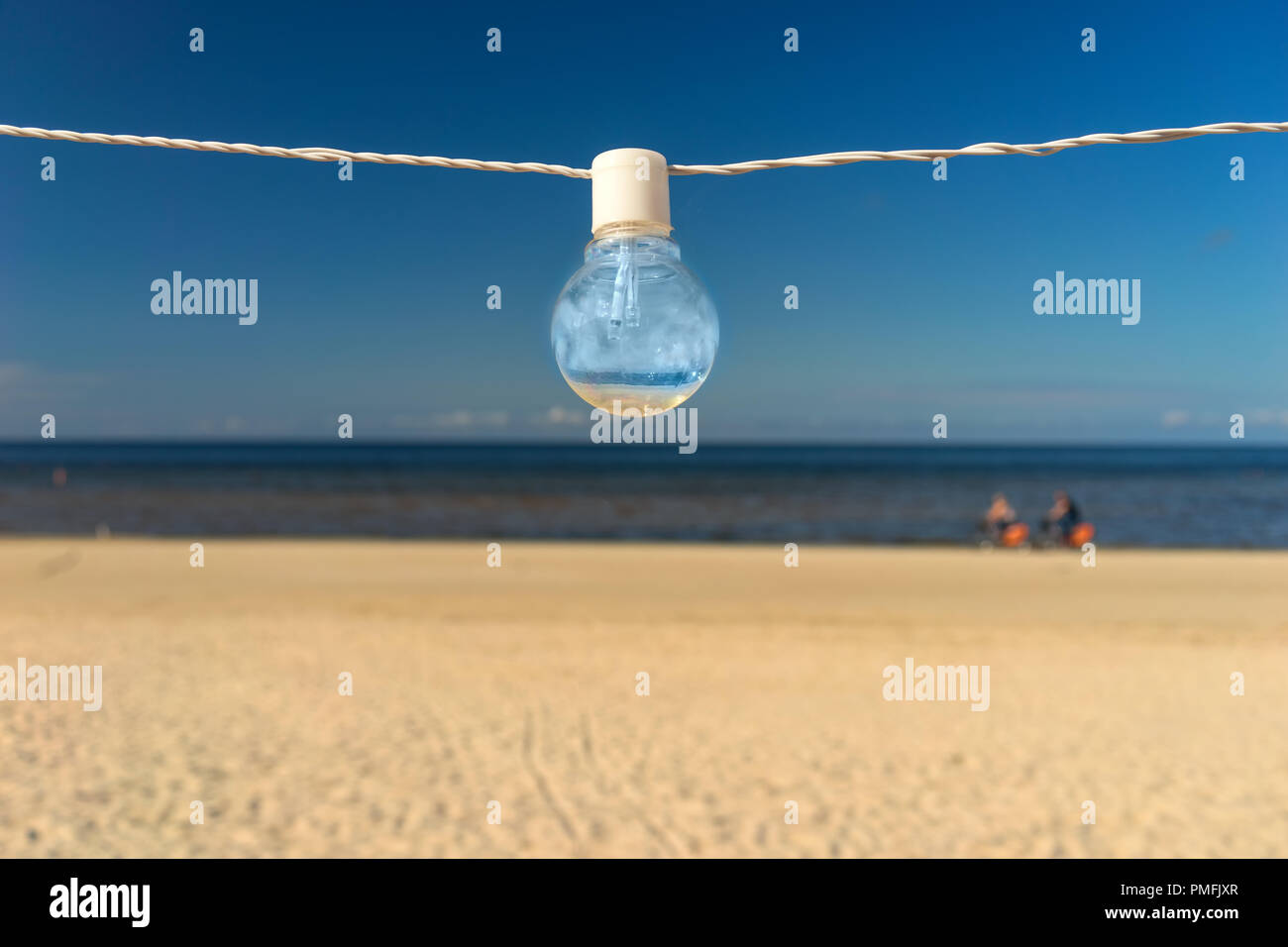 Light bulb on the wire on the beach Stock Photo - Alamy