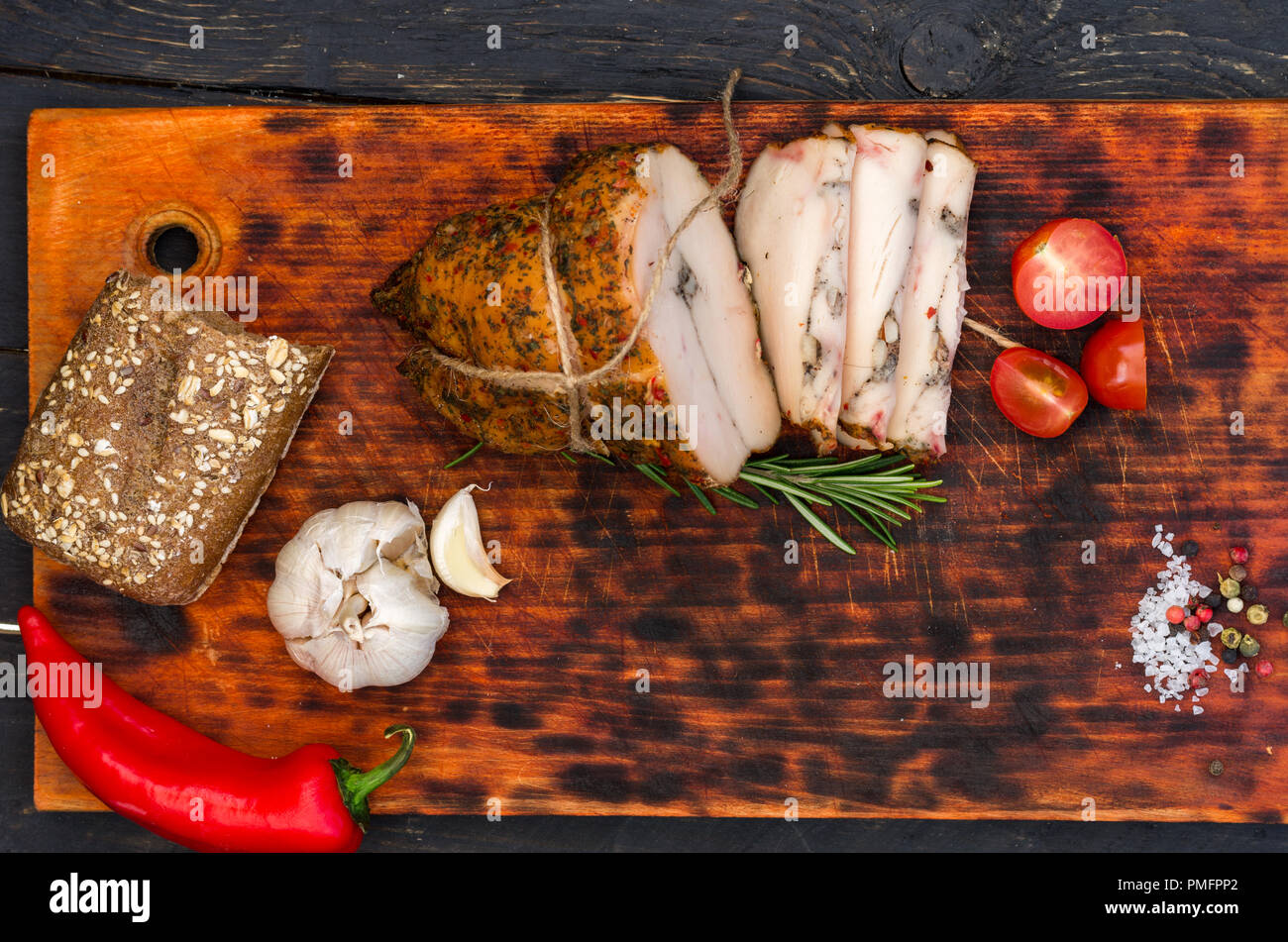 Slicing meat on the kitchen board. Homemade meat and spices. Flat lie ...