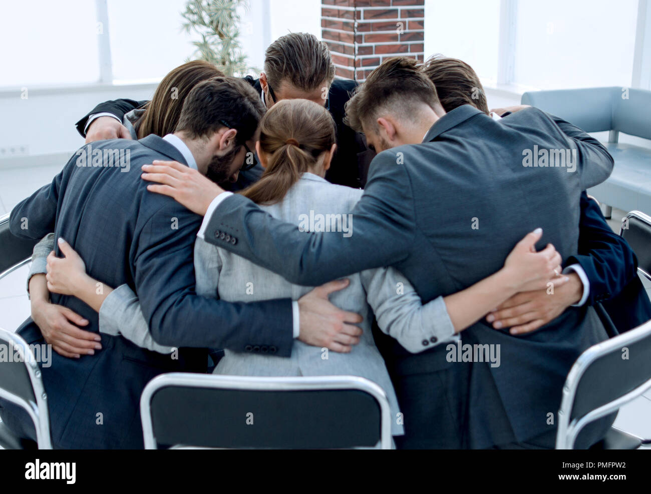 business team sits in a circle and hugs each other Stock Photo - Alamy