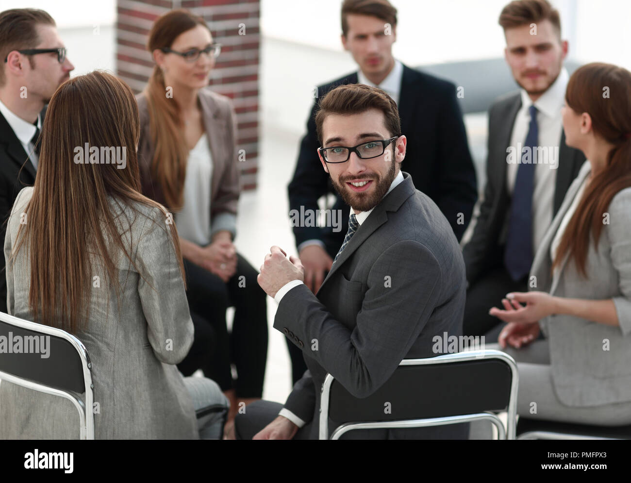 young employee sitting in a circle of colleagues Stock Photo - Alamy