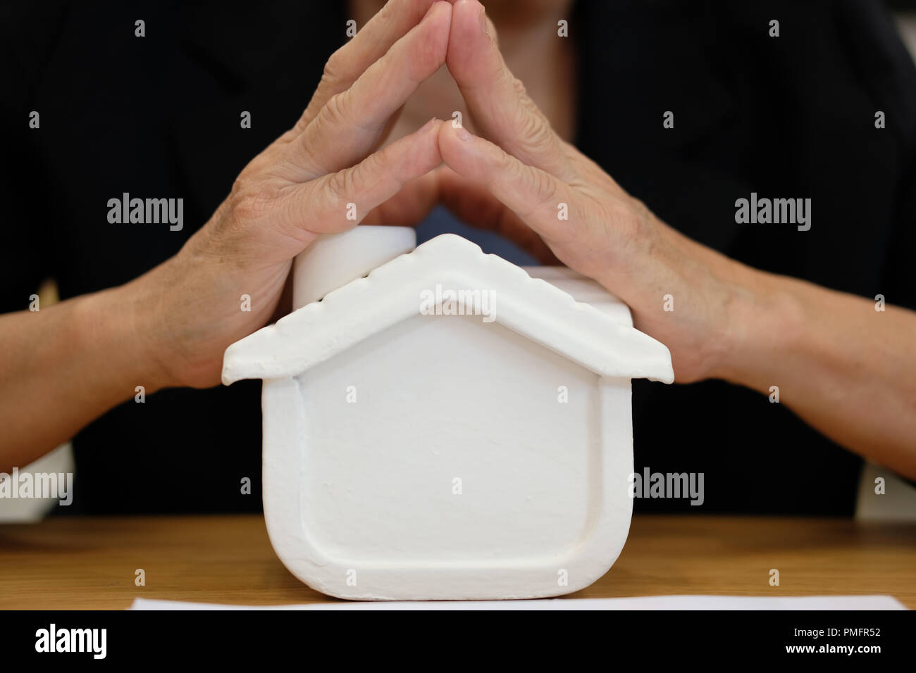 hand protecting house model. home insurance, safety & security concept ...