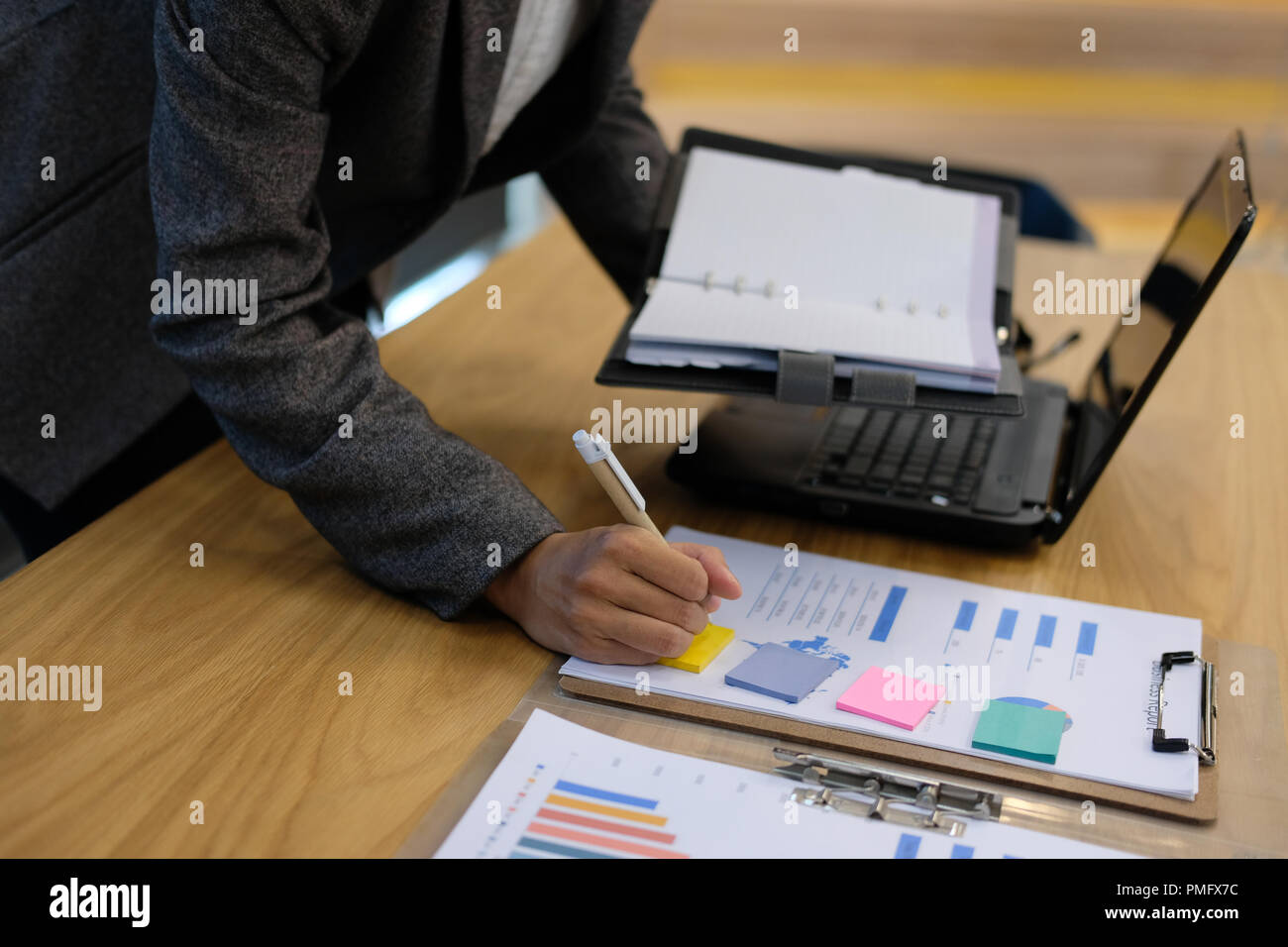 woman writing reminder schedule note on sticky notepad with computer ...