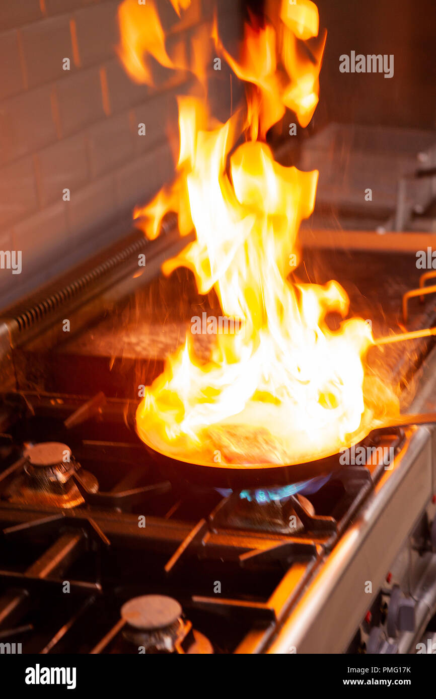 Chef cooking with high fire in kitchen restaurant Stock Photo - Alamy