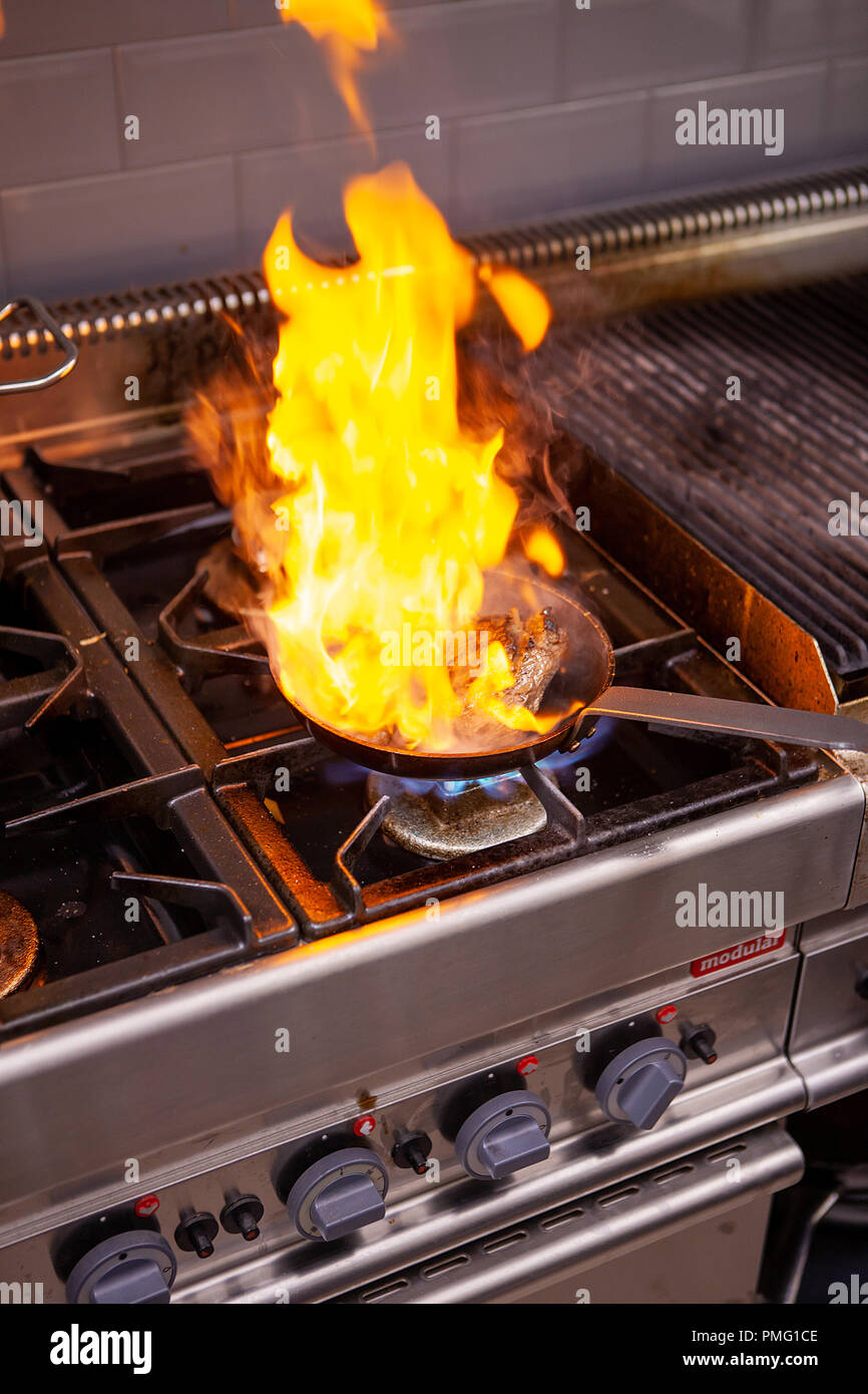 Chef making great flambe beef in restaurant kitchen Stock Photo - Alamy