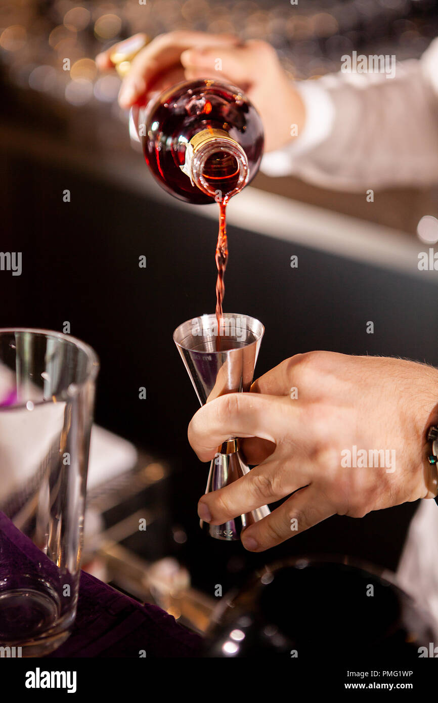 Closeup of bartender hands pouring alcoholic drink.Professional drink ...