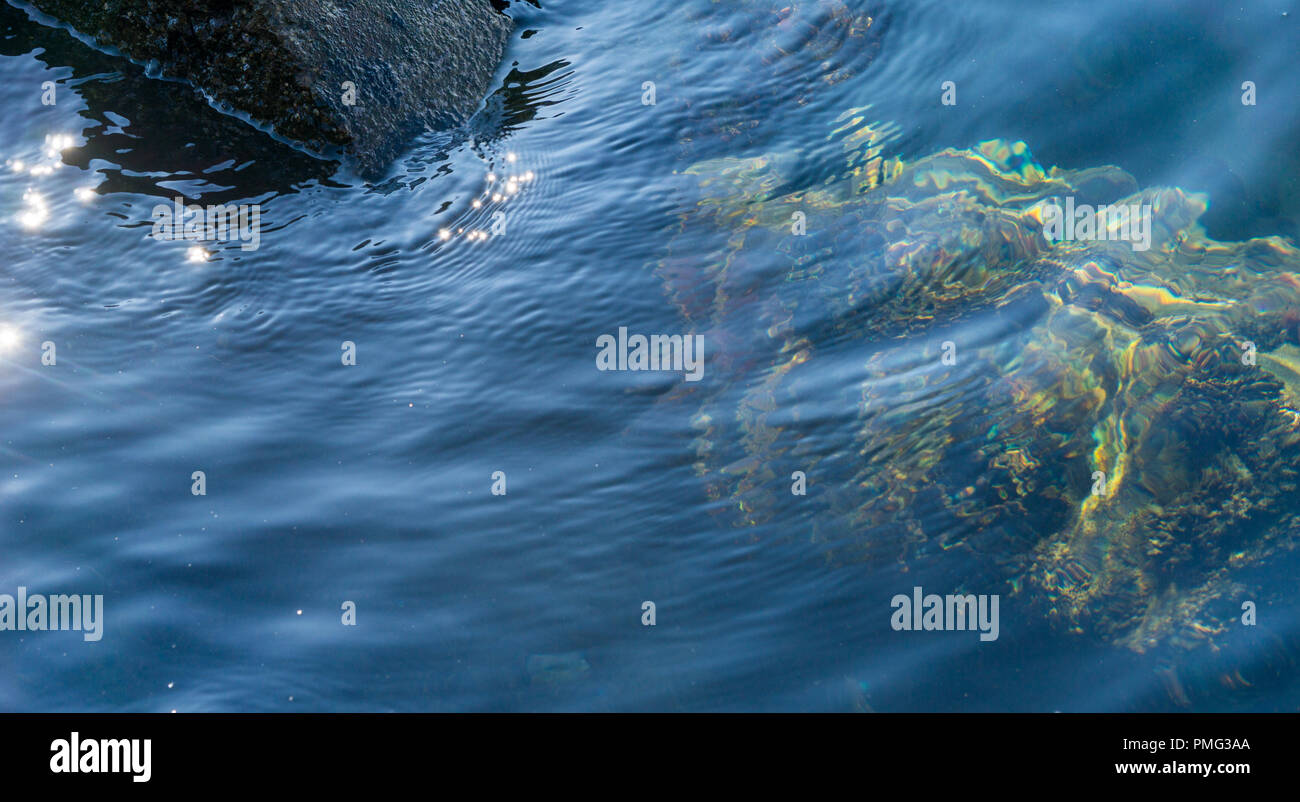 Colorful rocks submerging in the sea water Stock Photo - Alamy