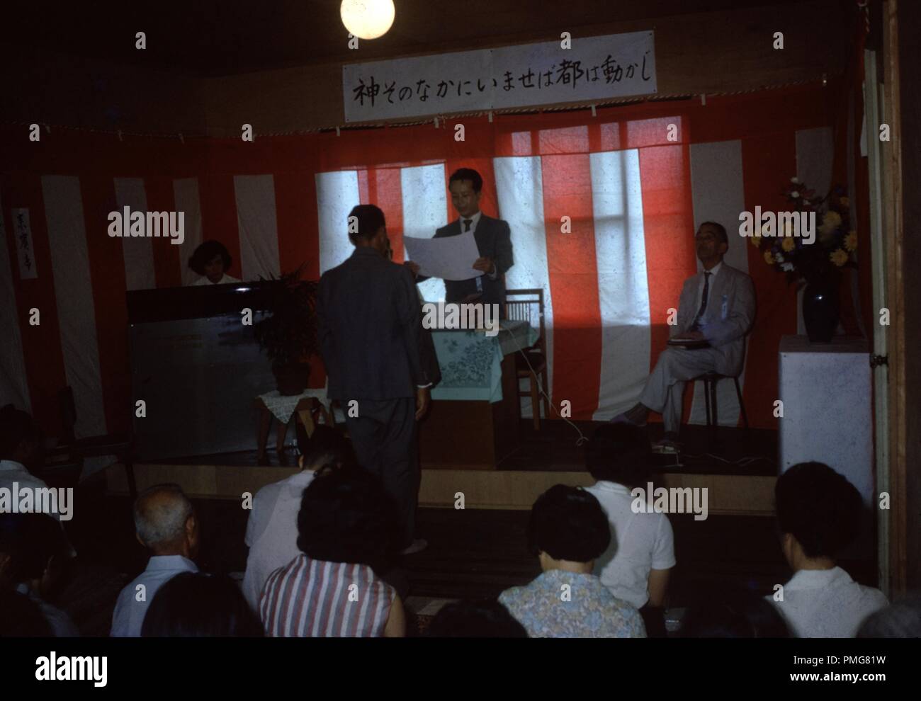 Priest conducting religious service, reading from a script to local ...