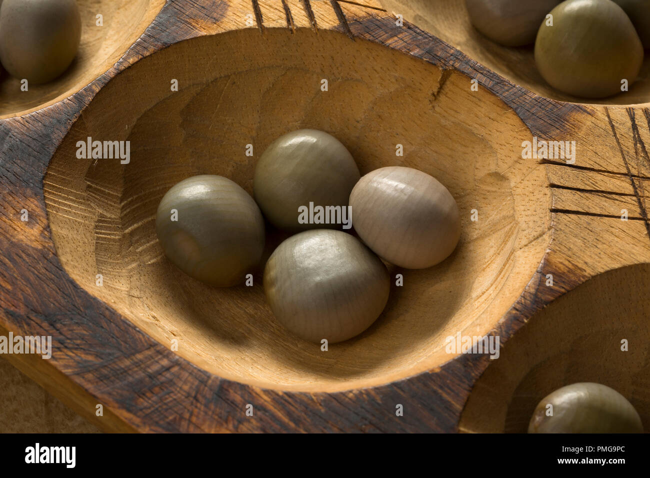 Traditional African oware game with seeds isolated on white background ...