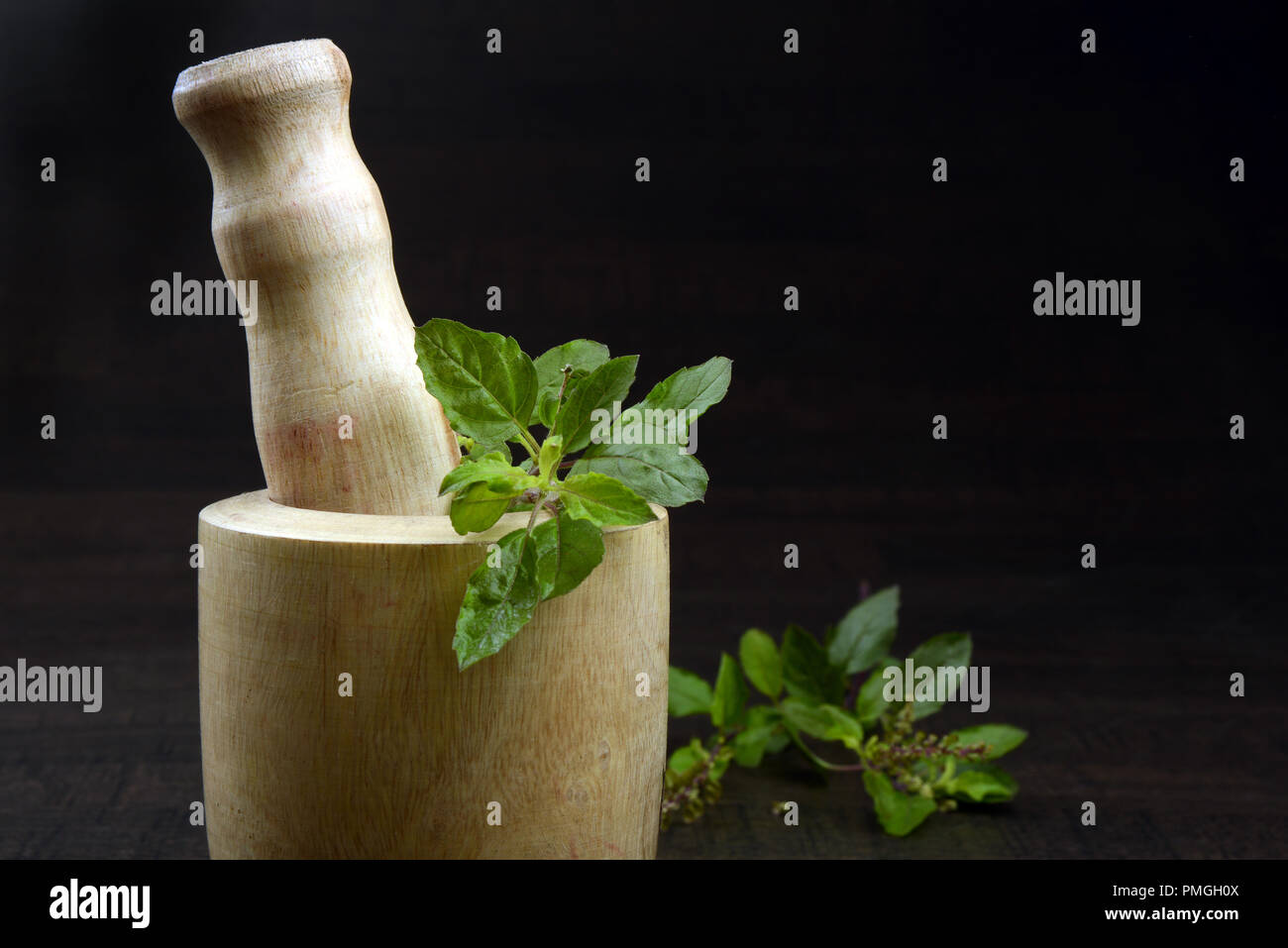 Holy Basil, Turmeric, Datura Fruit with Herbal oil and wooden mortar on ...