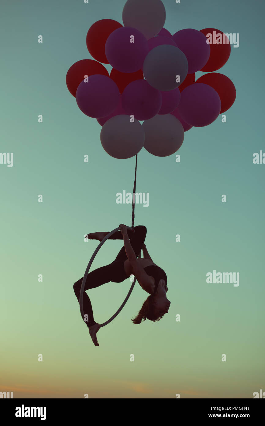 Girl gymnast doing tricks in the air on a circle and balloons Stock ...