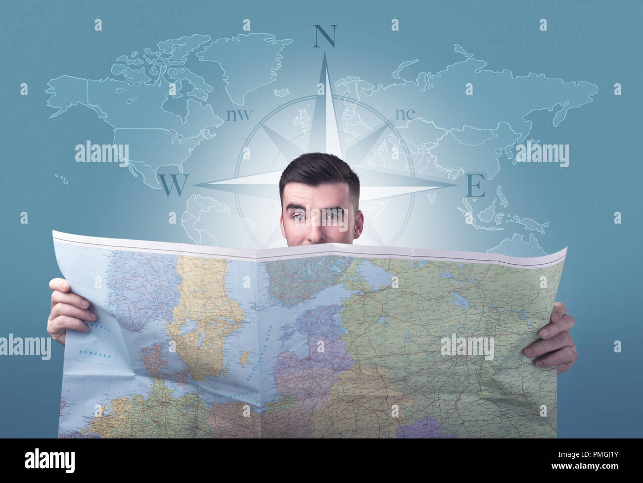 Handsome young man holding a map with a world map and a compass behind ...