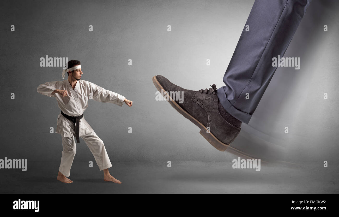 Big foot treading small young karate man Stock Photo - Alamy