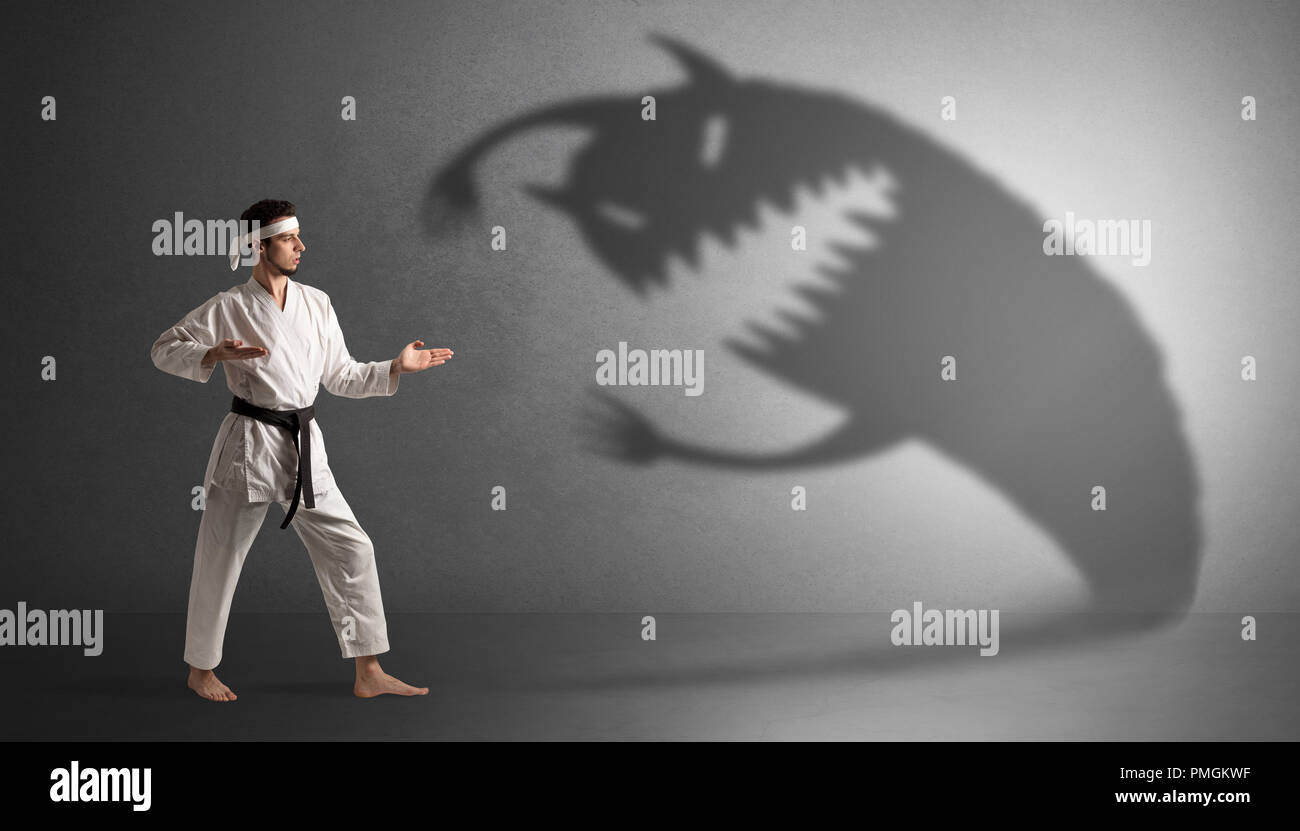 Young karate man fighting with a big black scary shadow Stock Photo - Alamy