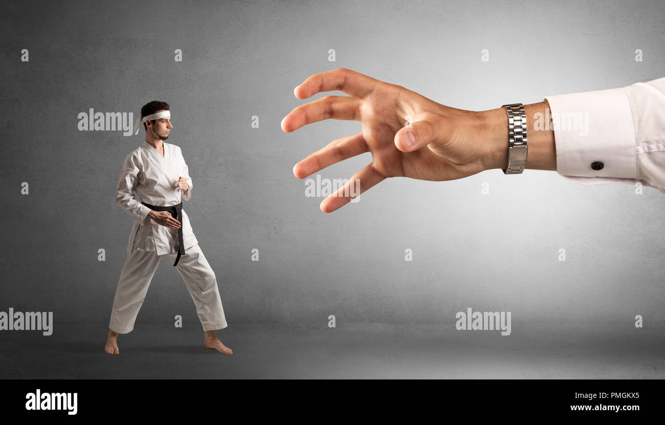 Small karate man fighting with big hand Stock Photo - Alamy